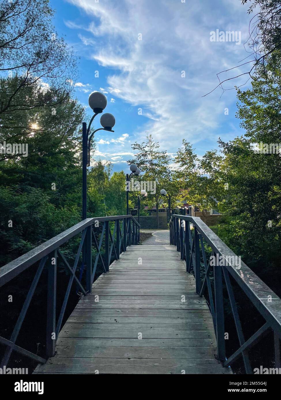 A wooden bridge with a lamp post and street lights Stock Photo - Alamy