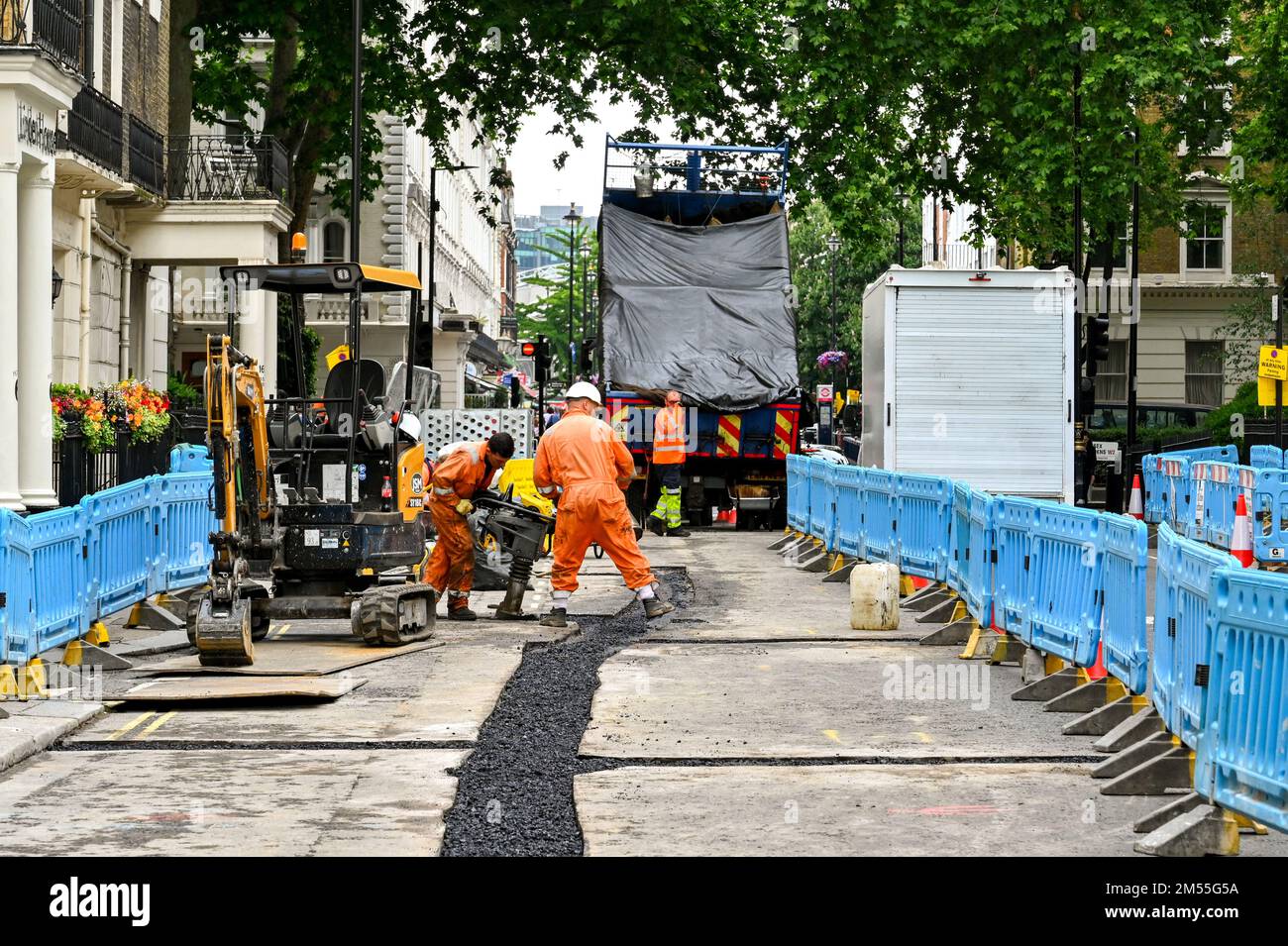 London, England, UK - June 2022: Workers filling in a trench after ...