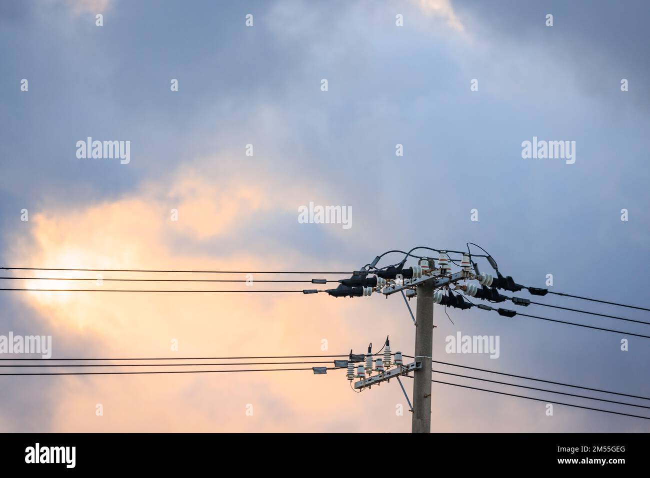 High voltage power lines and storm clouds at sunrise Stock Photo - Alamy