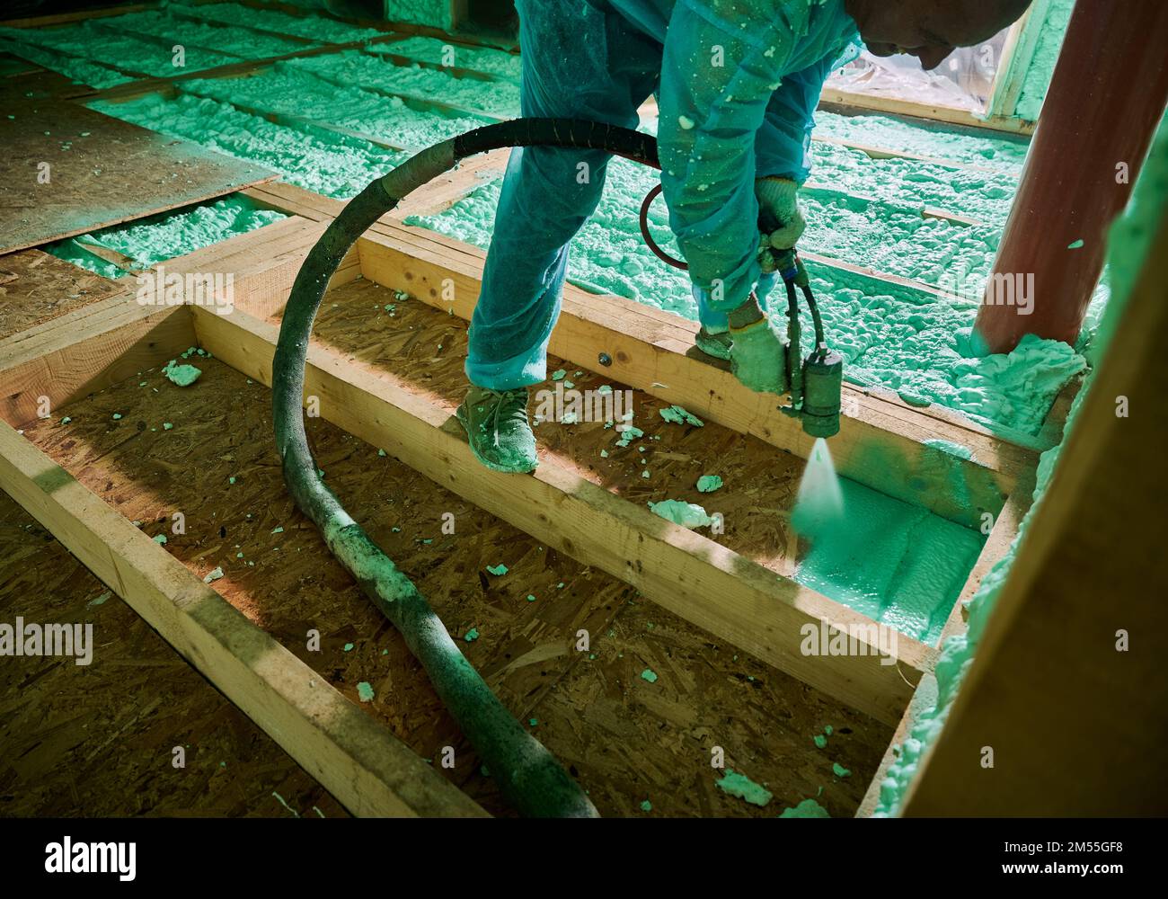 Male builder insulating wooden frame house. Cropped view of man worker ...