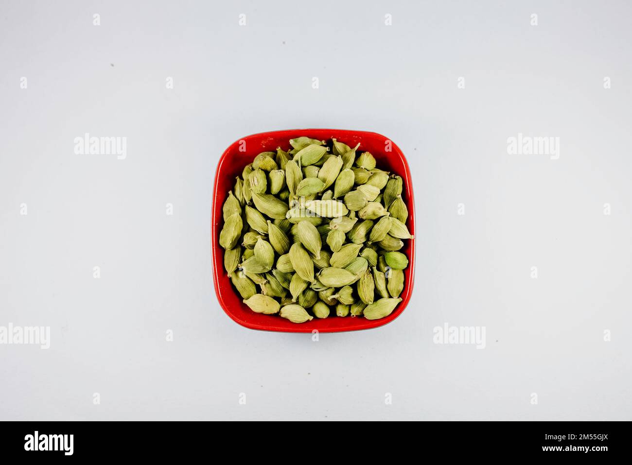A pile of green cardamom in a bowl isolated on white background Stock ...
