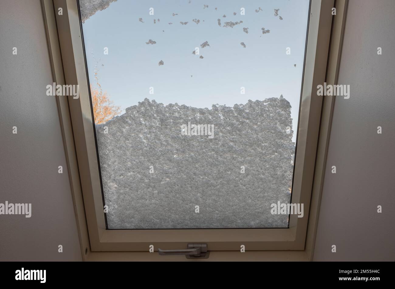 Close up view of interior of snow-covered dormer window on roof of ...