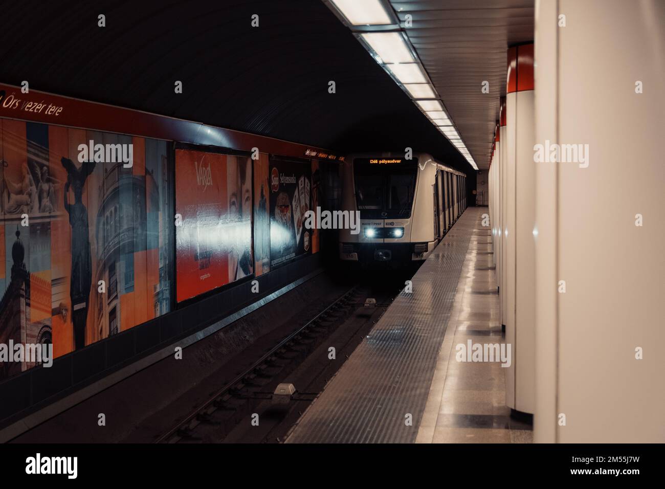 An empty subway platform with pictures of landmarks on the walls in ...