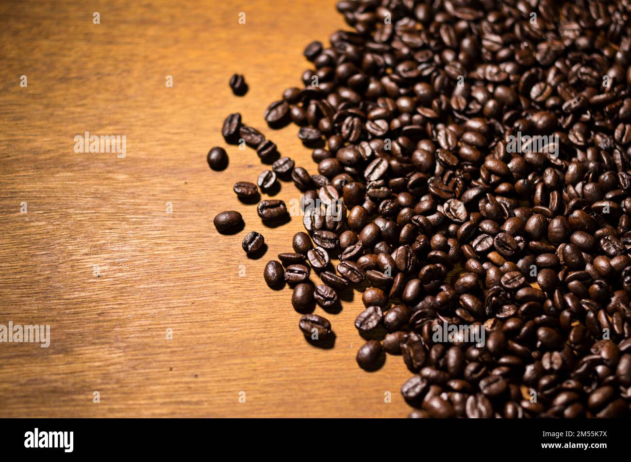 A closeup of roasted coffee beans on a wooden background Stock Photo ...