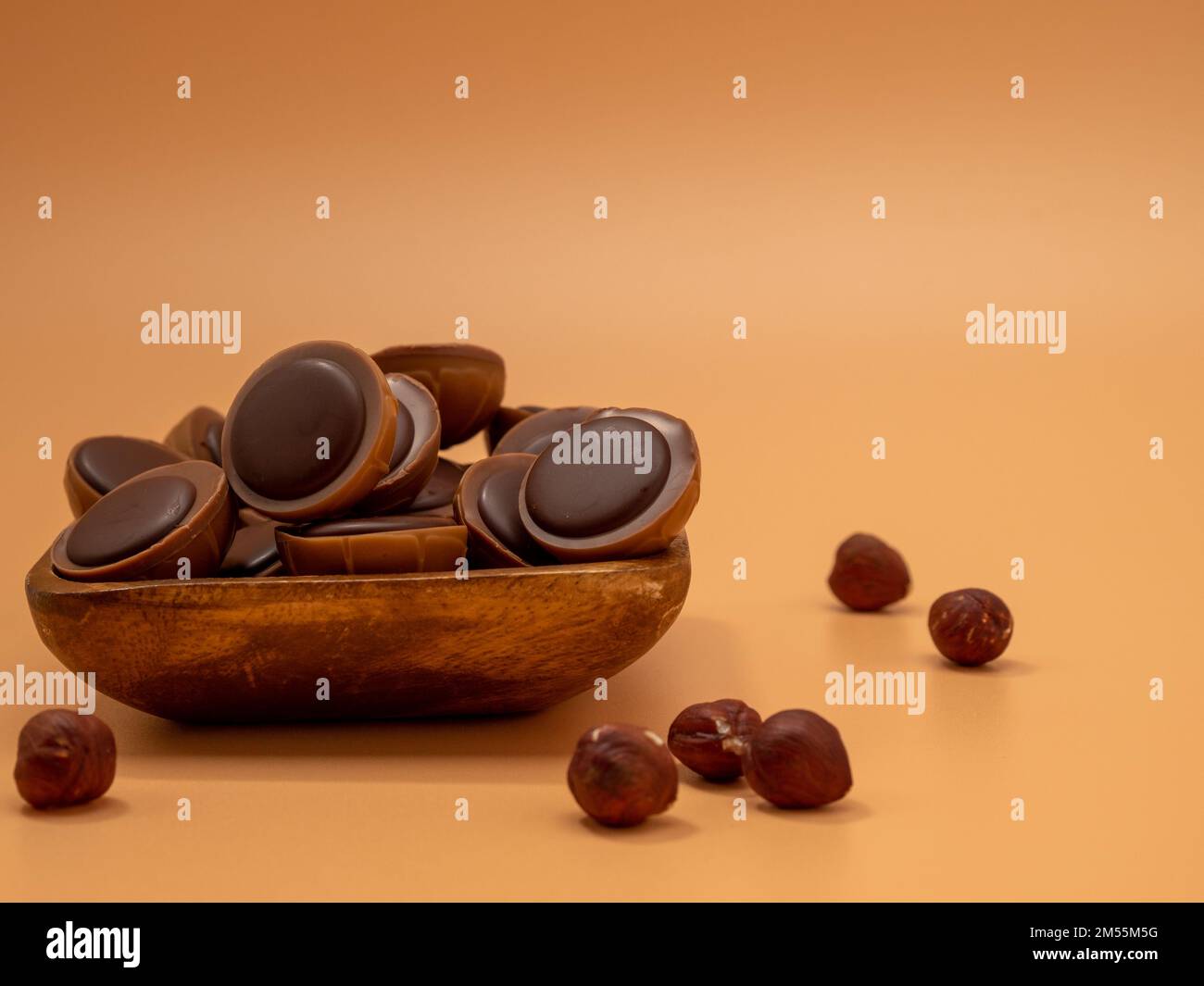 Chocolate candies on an orange background. Sweets with caramel. Round ...