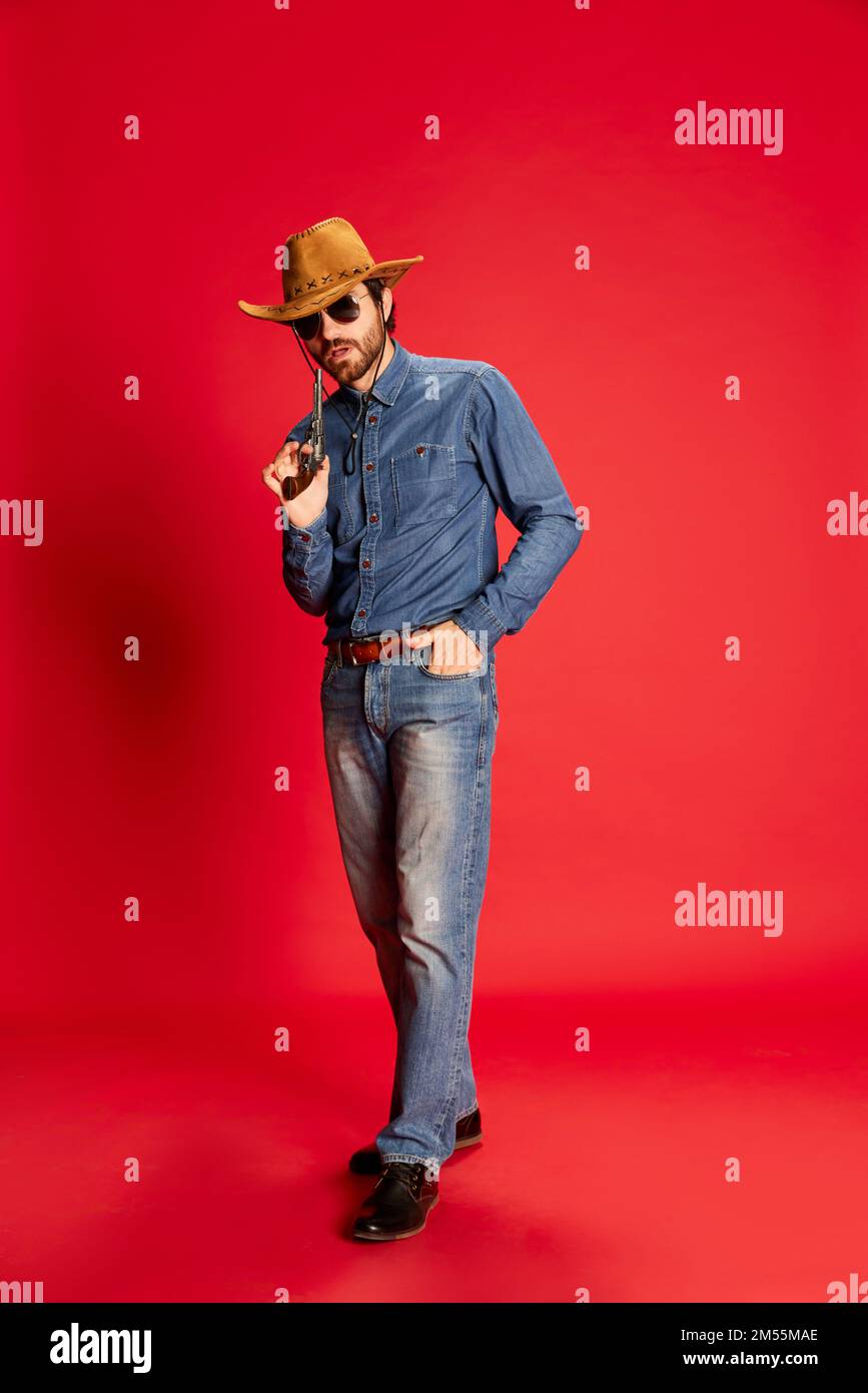 Excited young man in cowboy style outfit having fun, posing isolated ...