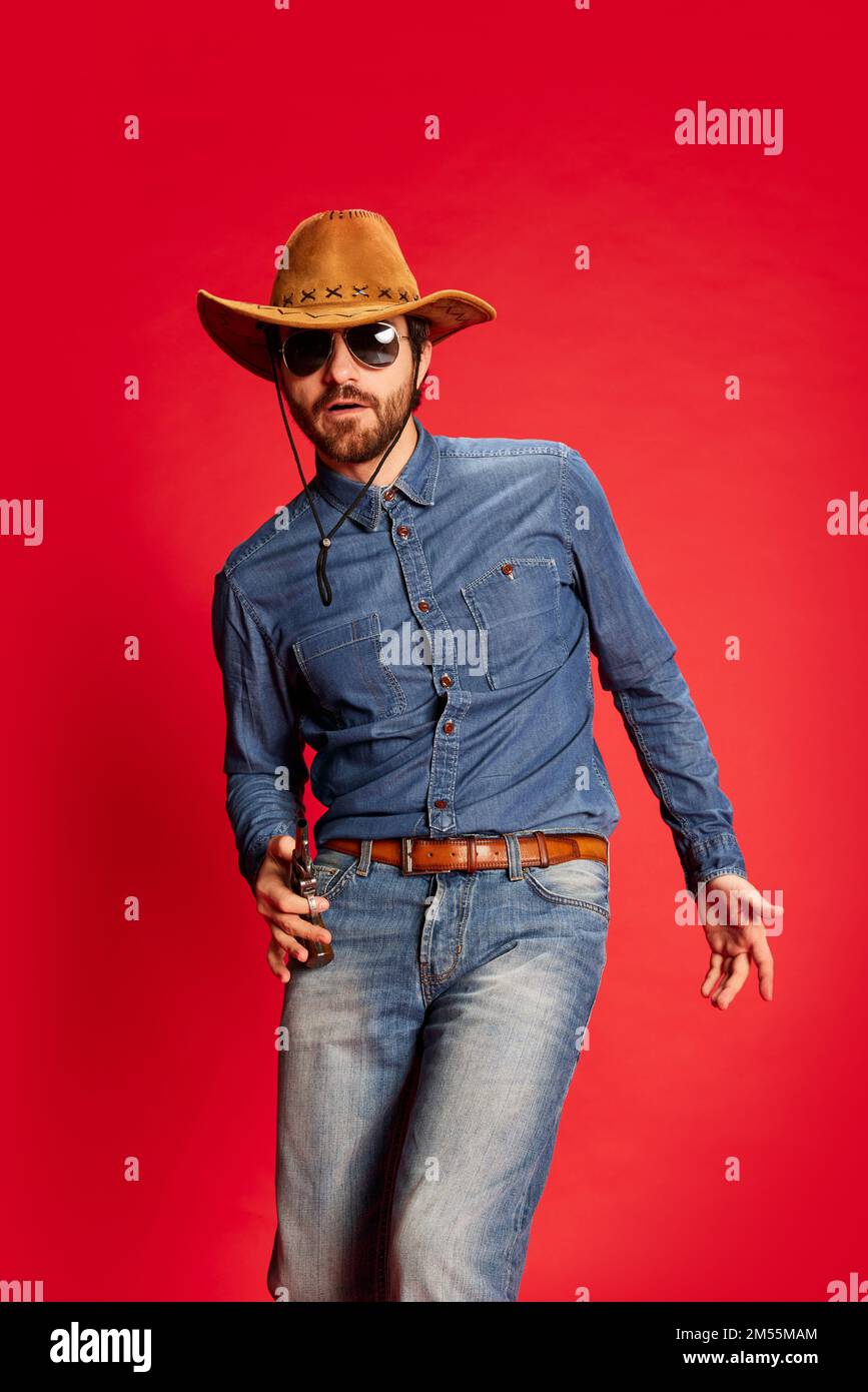 Excited young man in cowboy style outfit having fun, posing isolated ...