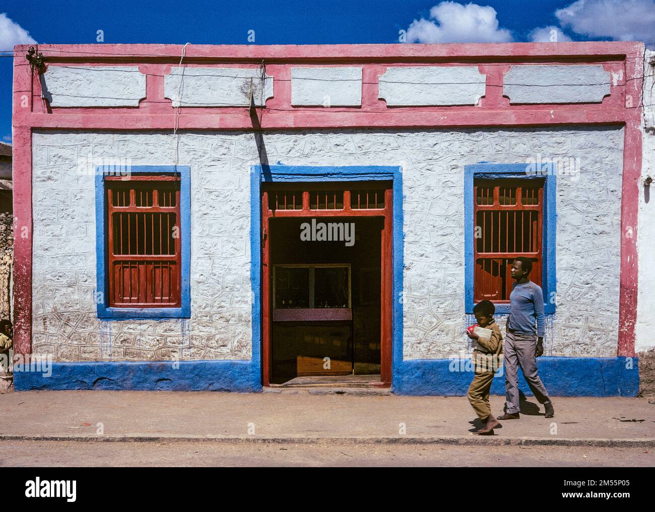 Ethiopia, 1970s, Harar, man and boy walking in front of a white pink an ...
