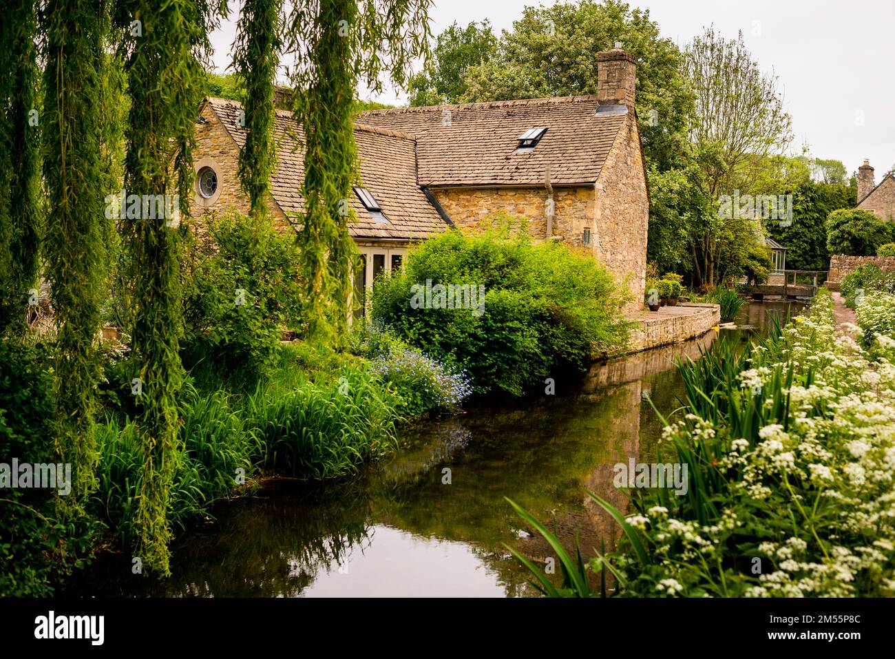 Cotswold stone house beside the River Windrush near the village of ...
