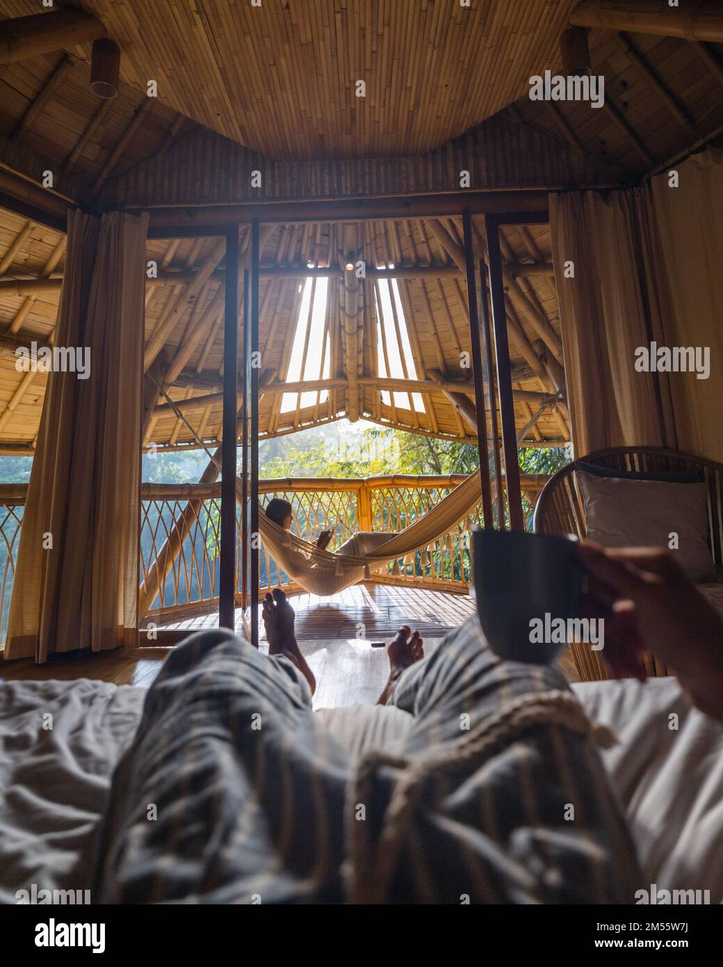A vertical shot of male legs laying in bed with a female laying on a ...