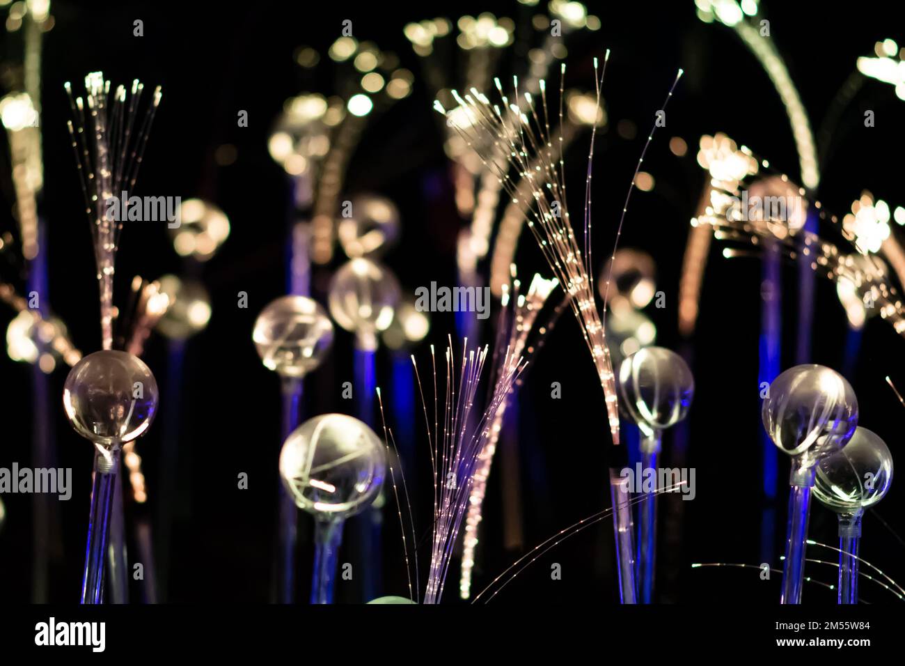 White, golden yellow and blue fiber optic strands or filaments creating ...