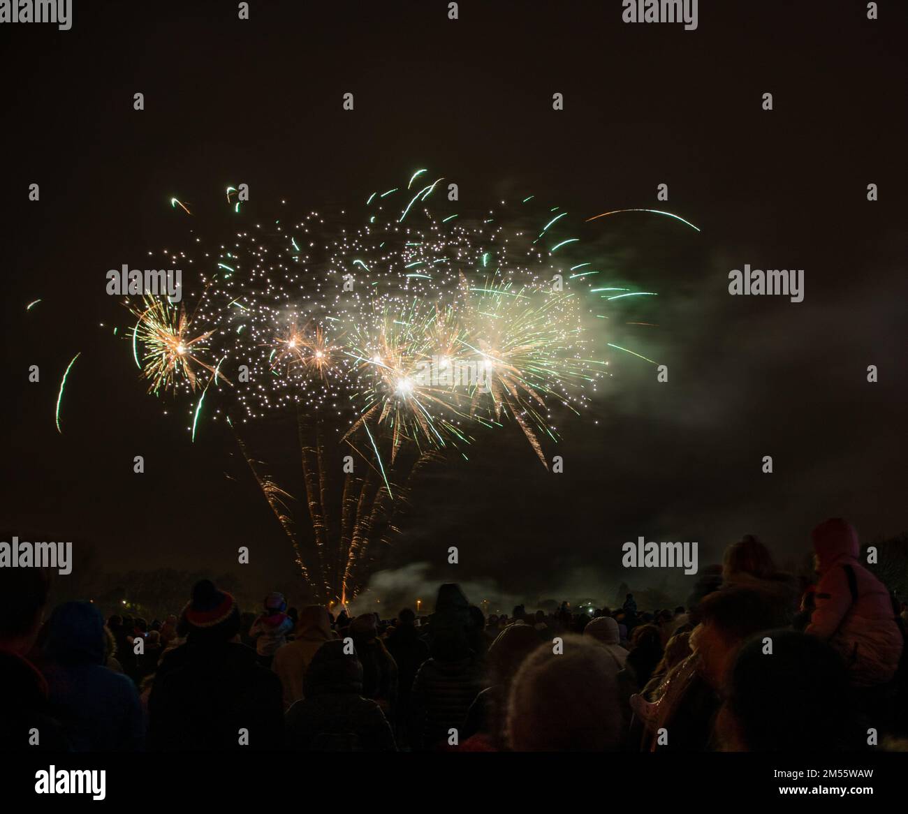 The crowd enjoying the beautiful fireworks at night during an outdoor ...