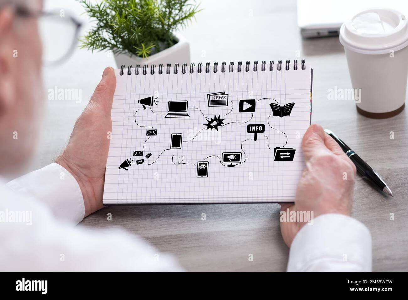 Hand holding a notepad with communication media concept Stock Photo - Alamy