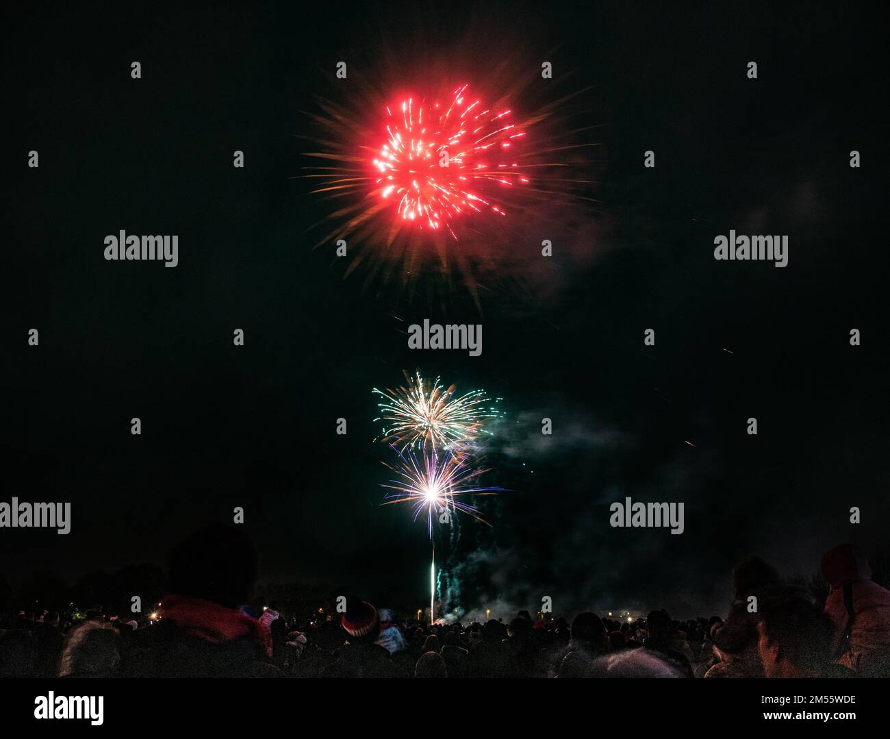 The crowd enjoying the beautiful fireworks at night during an outdoor ...
