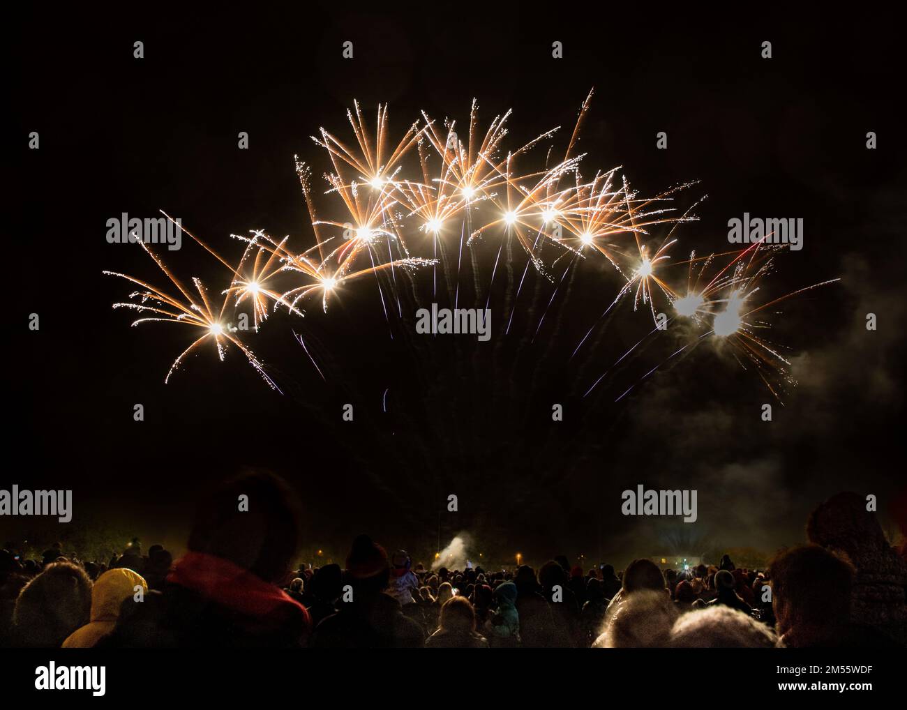 The crowd enjoying the beautiful fireworks at night during an outdoor ...