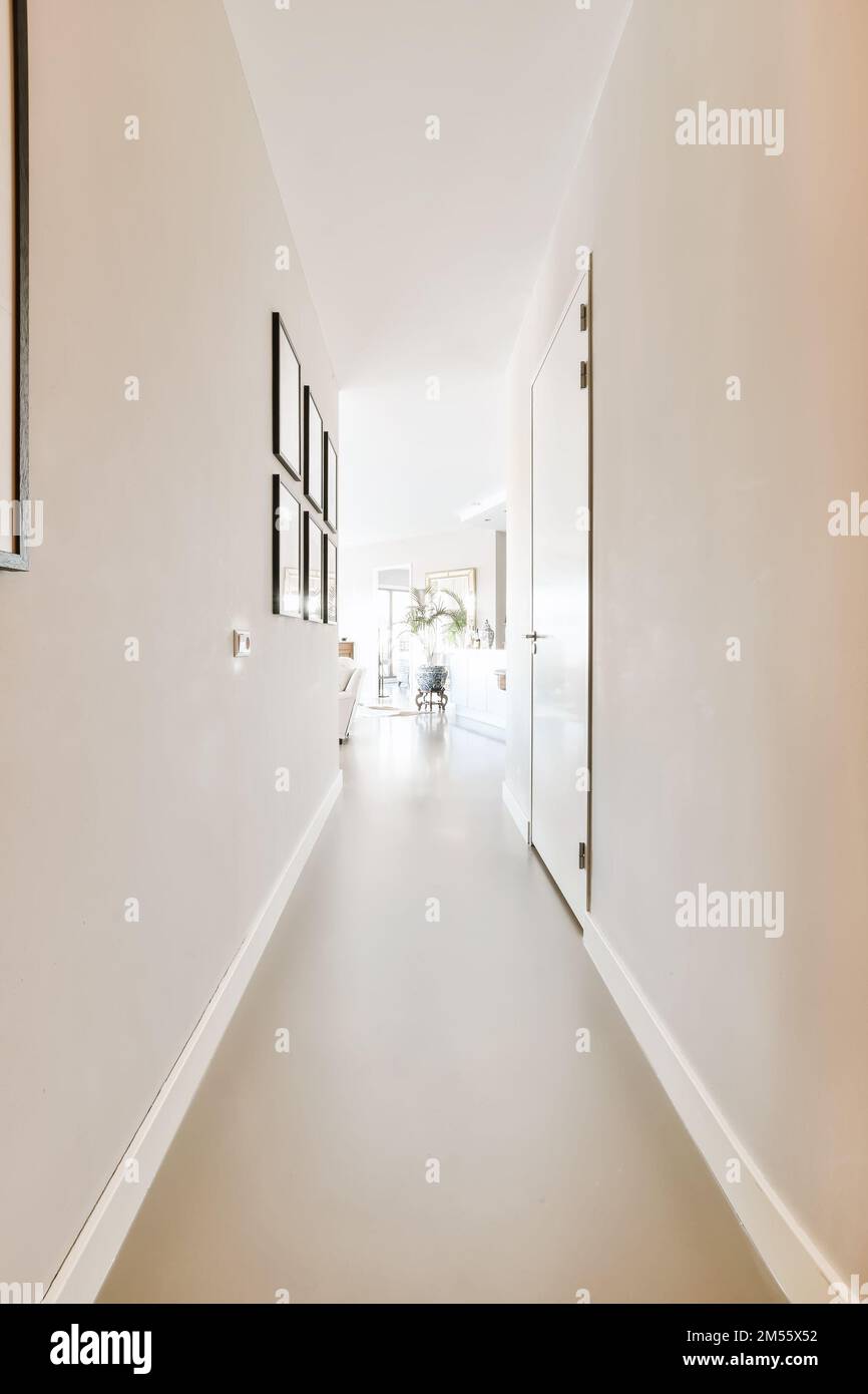 a long hallway with white walls and wood flooring the room is well lit ...