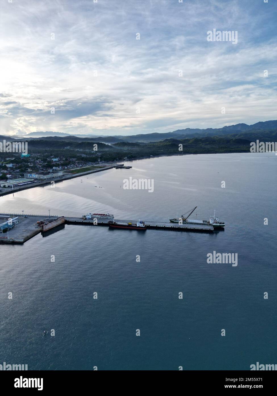 A beautiful view of a pier on the sea with boats under the blue cloudy ...