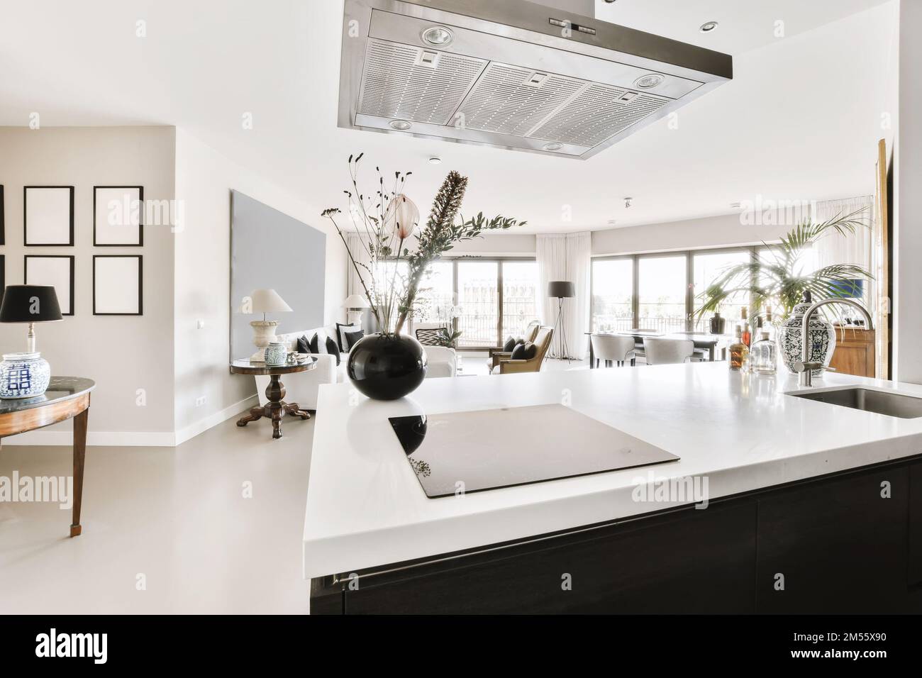 a modern kitchen with white counter tops and black appliances in the ...