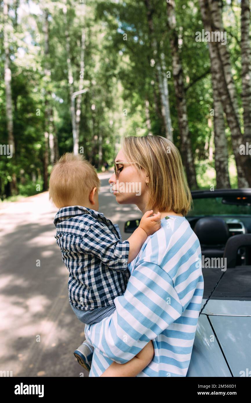 Mom and little son in a convertible car. Summer family road trip to ...
