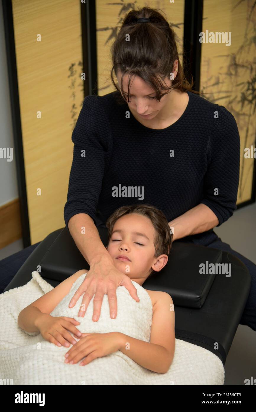 Caucasian woman practicing osteopathy on a child in her office Stock ...