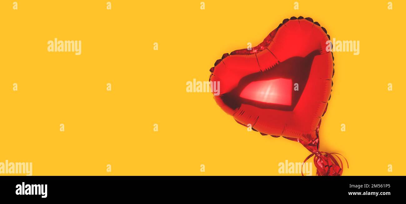 Banner with red inflatable foil balloon in a heart shape. Minimal ...