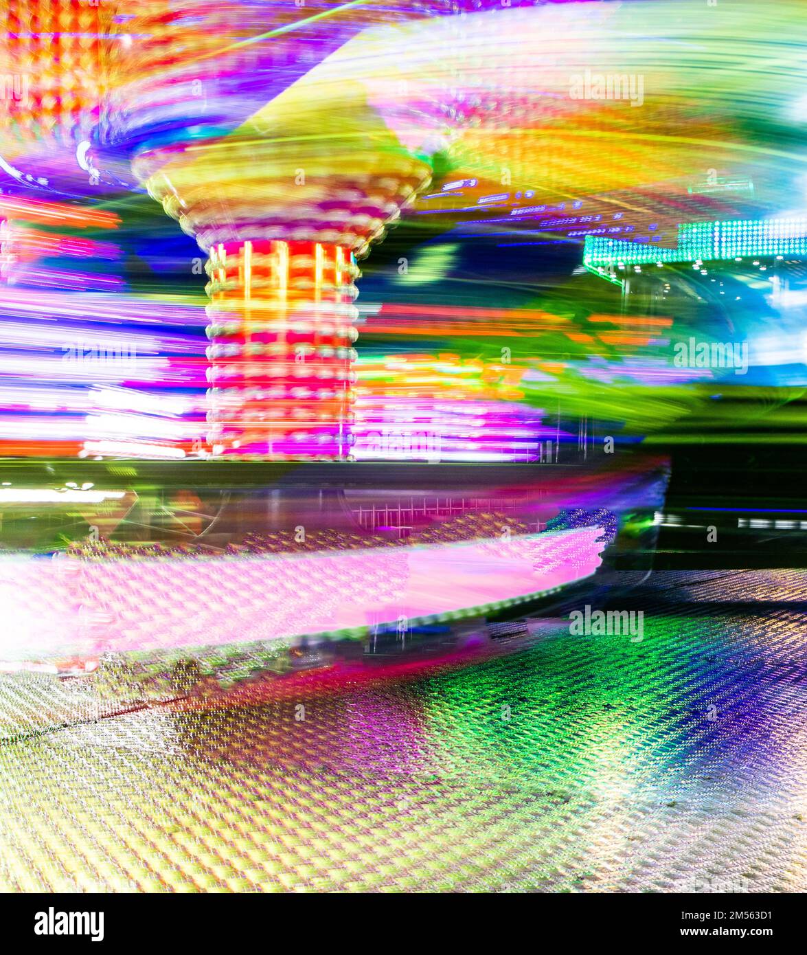 A vertical colorful long-exposure shot of the 'Twister' ride - fun fair ...