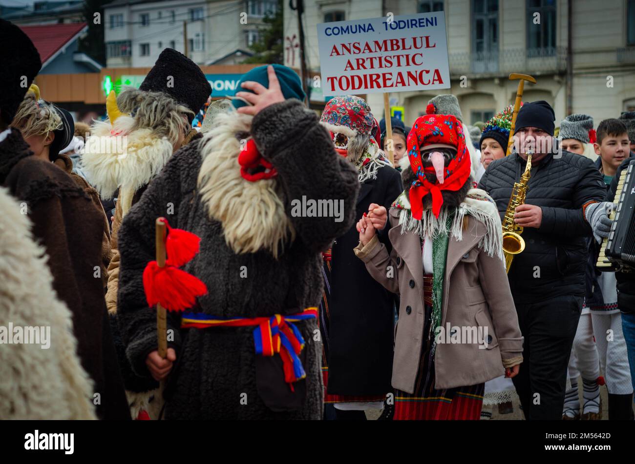 People wearing colorful costumes and masks perform during a traditional ...