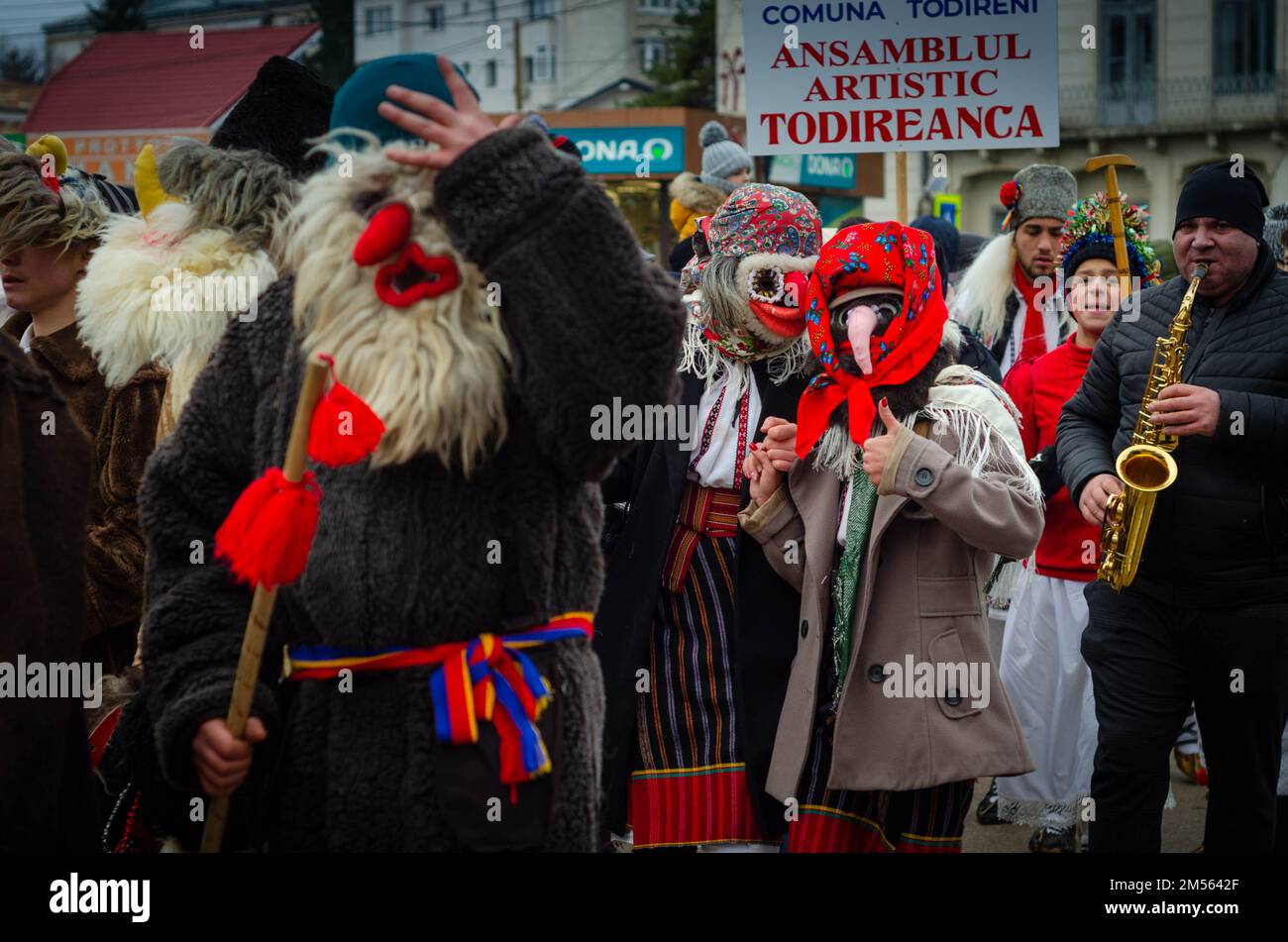 People wearing colorful costumes and masks perform during a traditional ...