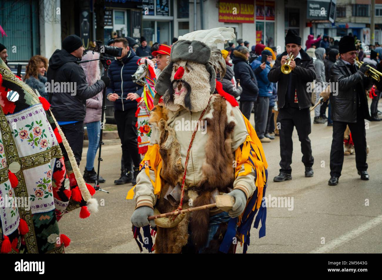 People wearing colorful costumes and masks perform during a traditional ...