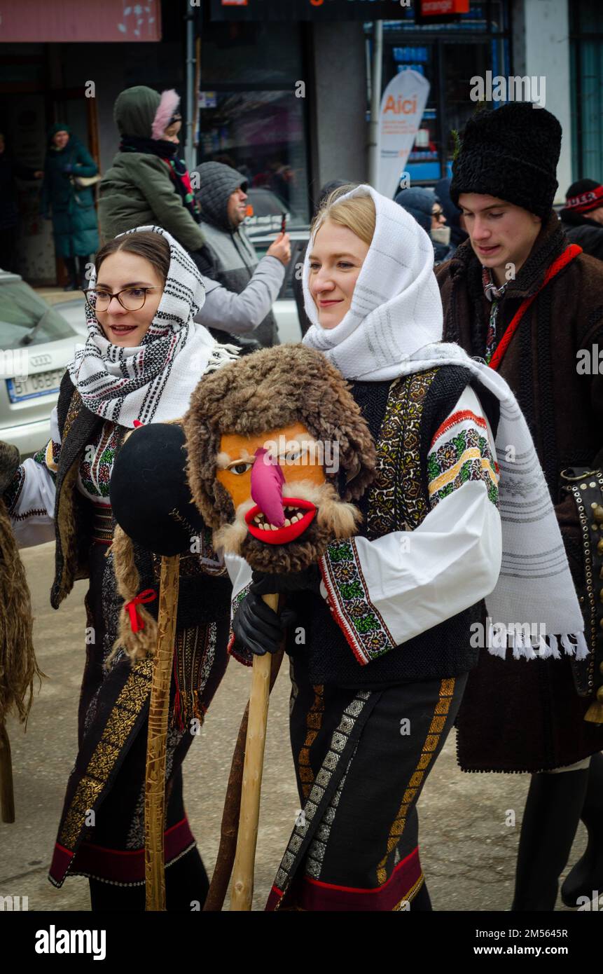 People wearing colorful costumes and masks perform during a traditional ...