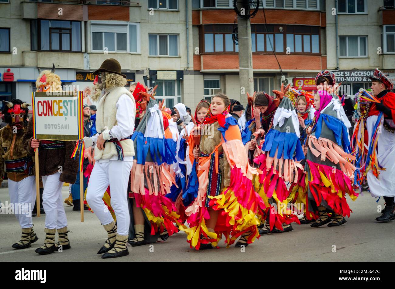 People wearing colorful costumes and masks perform during a traditional ...