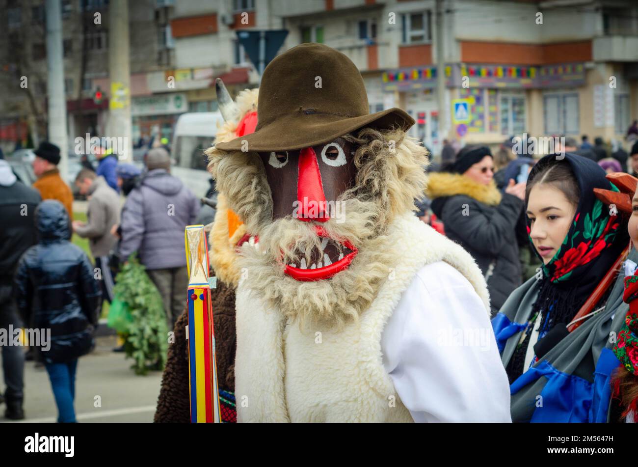 People wearing colorful costumes and masks perform during a traditional ...