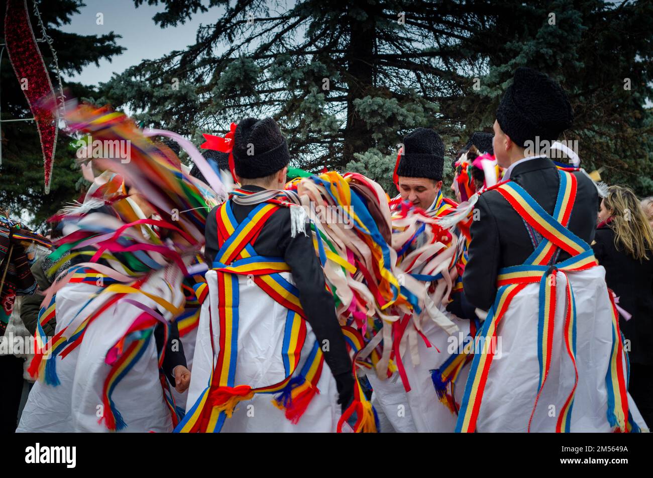 People wearing colorful costumes and masks perform during a traditional ...