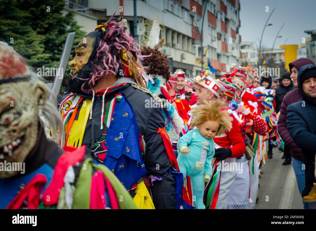 People wearing colorful costumes and masks perform during a traditional ...