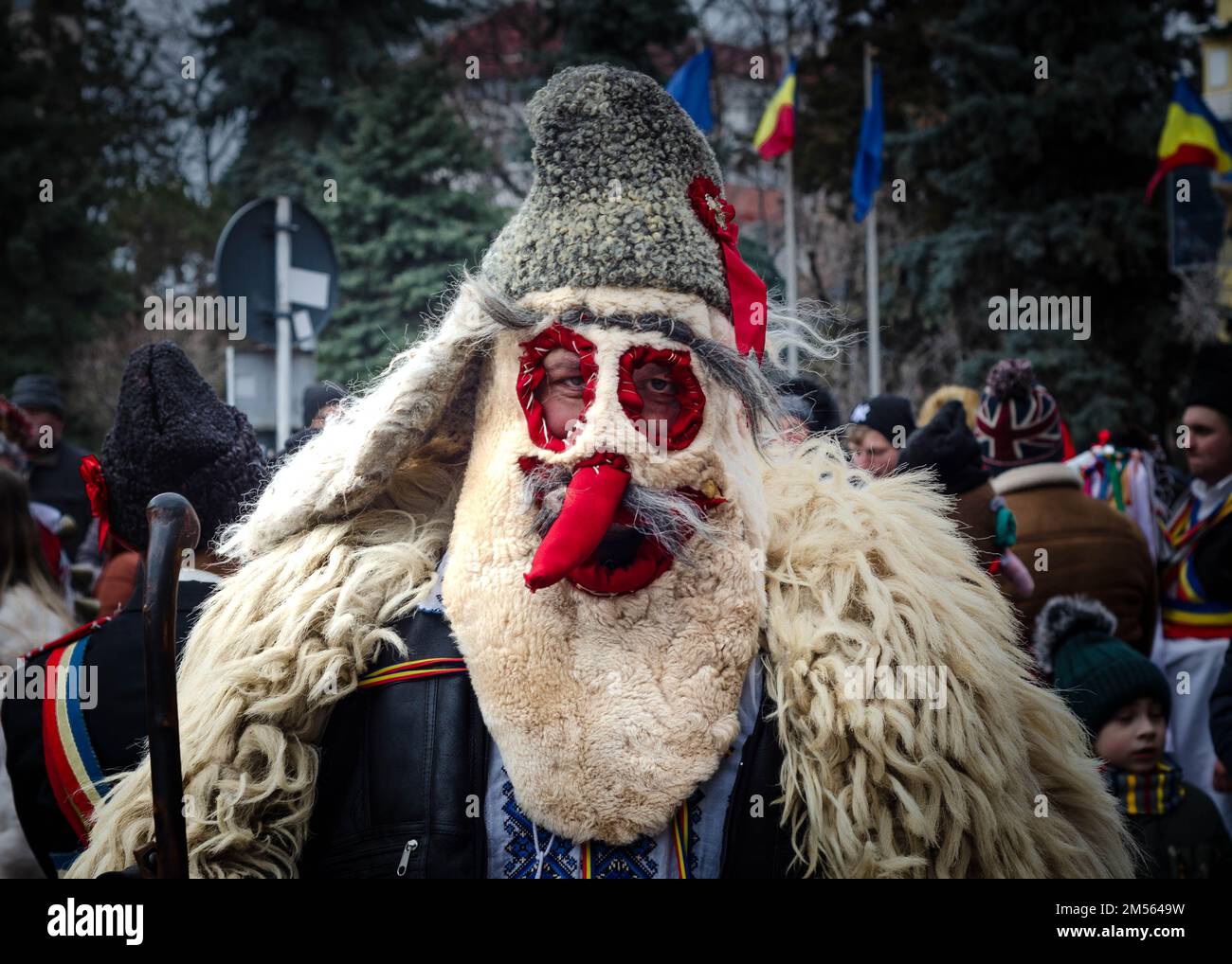 People wearing colorful costumes and masks perform during a traditional ...