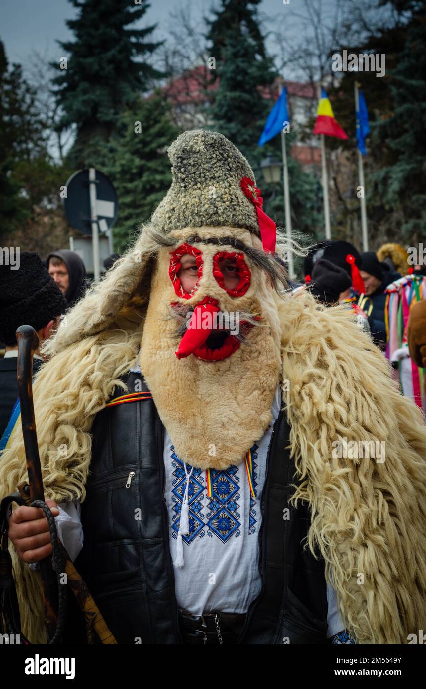 People wearing colorful costumes and masks perform during a traditional ...