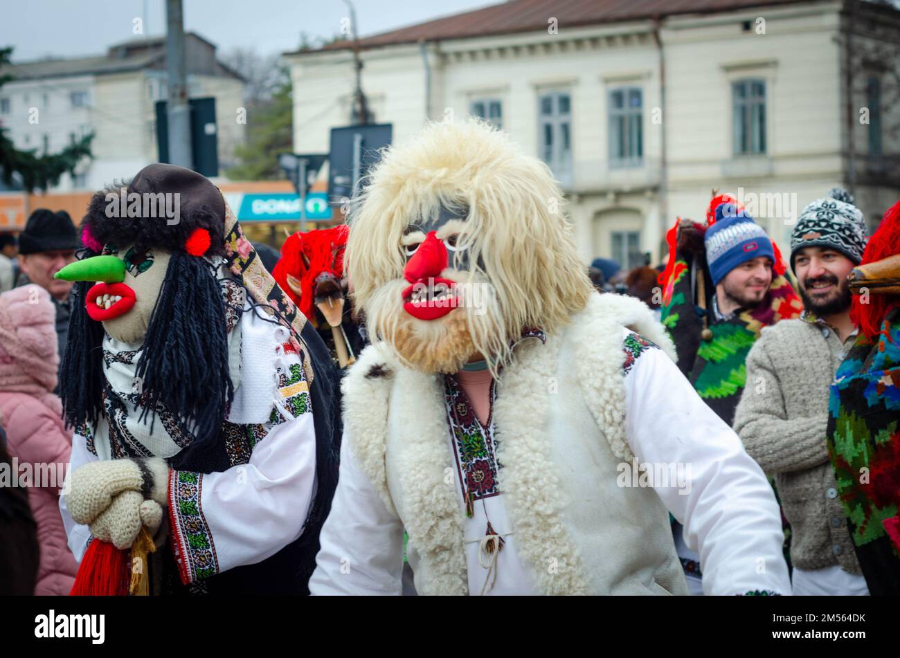 People wearing colorful costumes and masks perform during a traditional ...