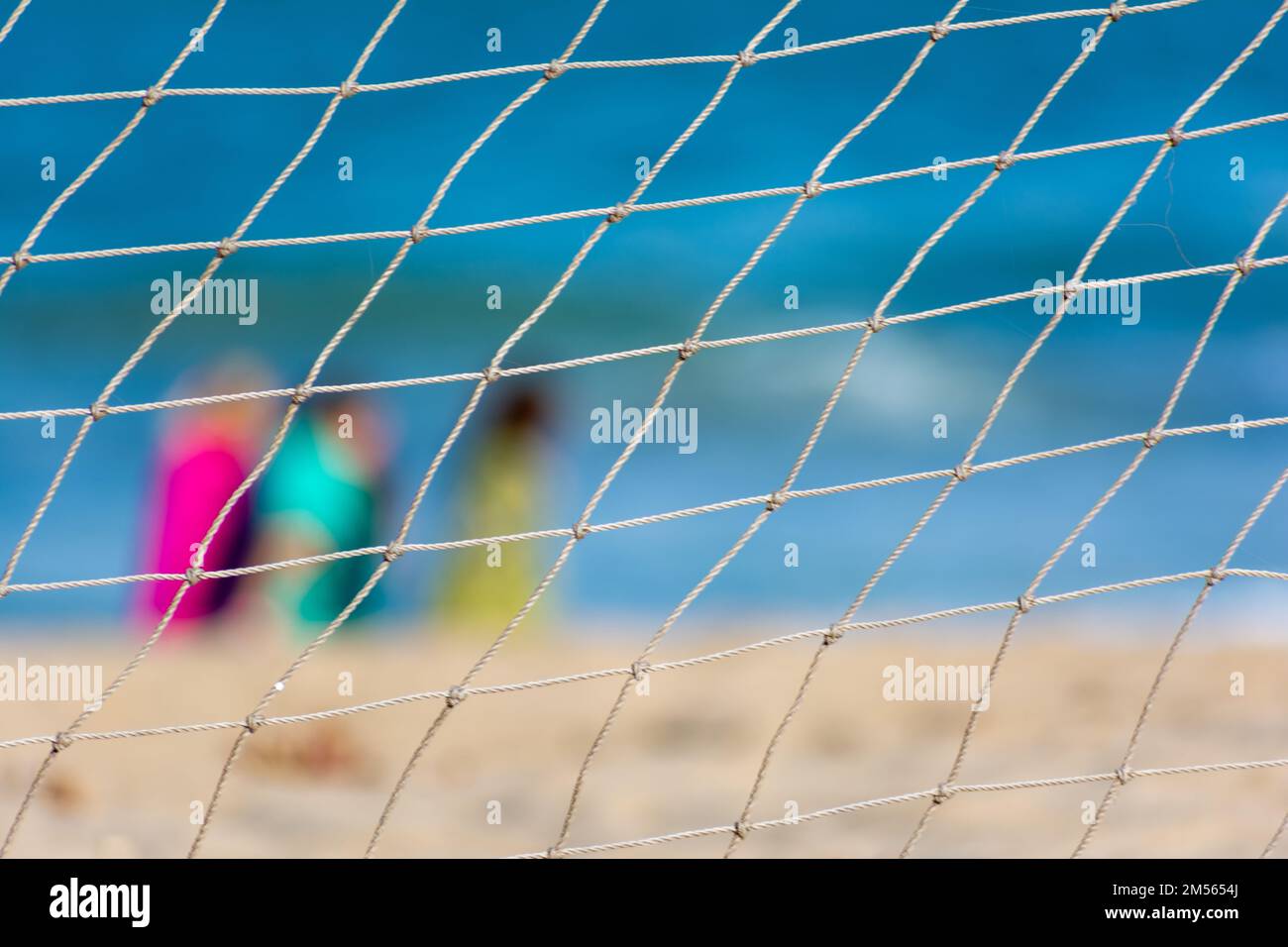 A thread net with pattern with blur people sitting on sandy beach Stock ...