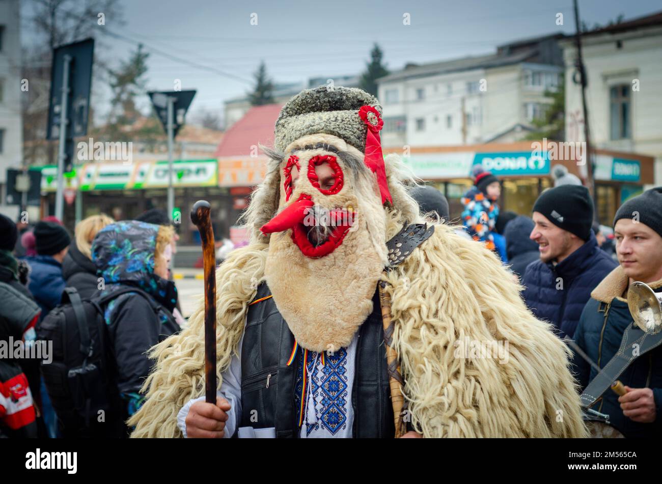 People wearing colorful costumes and masks perform during a traditional ...
