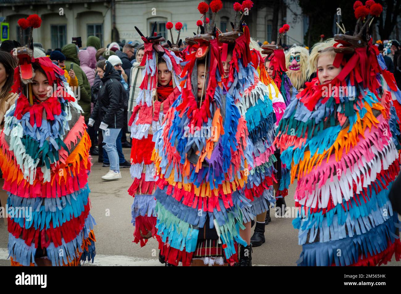 People wearing colorful costumes and masks perform during a traditional ...
