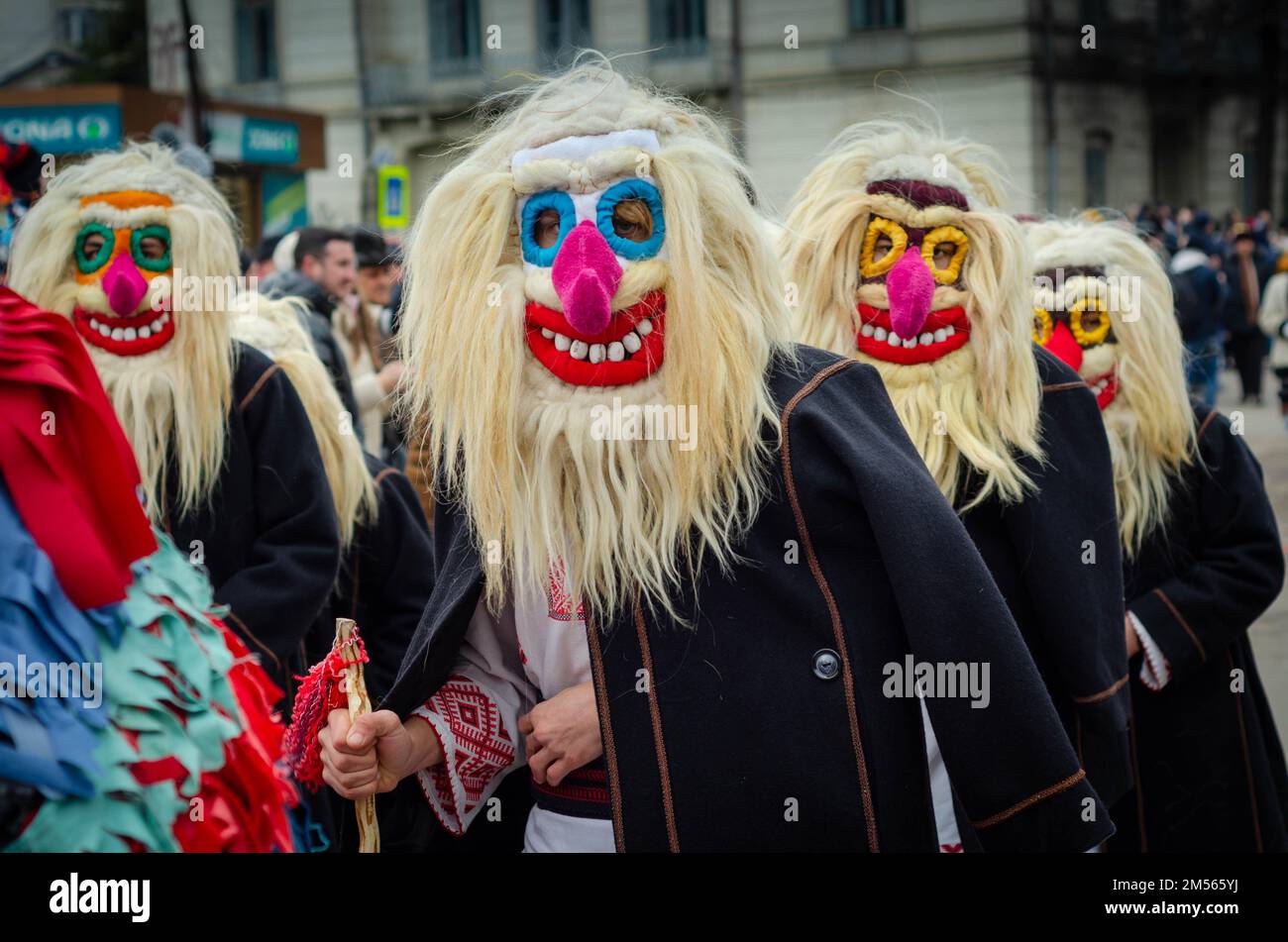 People wearing colorful costumes and masks perform during a traditional ...