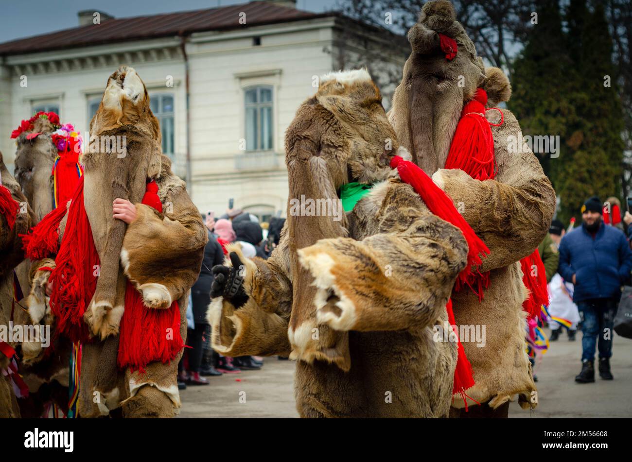 People wearing colorful costumes and masks perform during a traditional ...