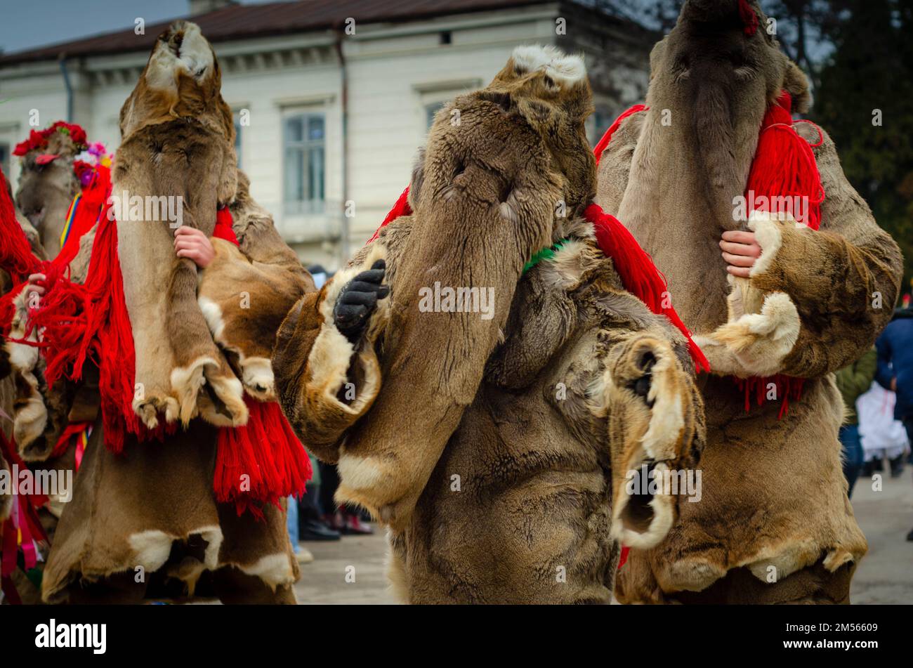 People wearing colorful costumes and masks perform during a traditional ...