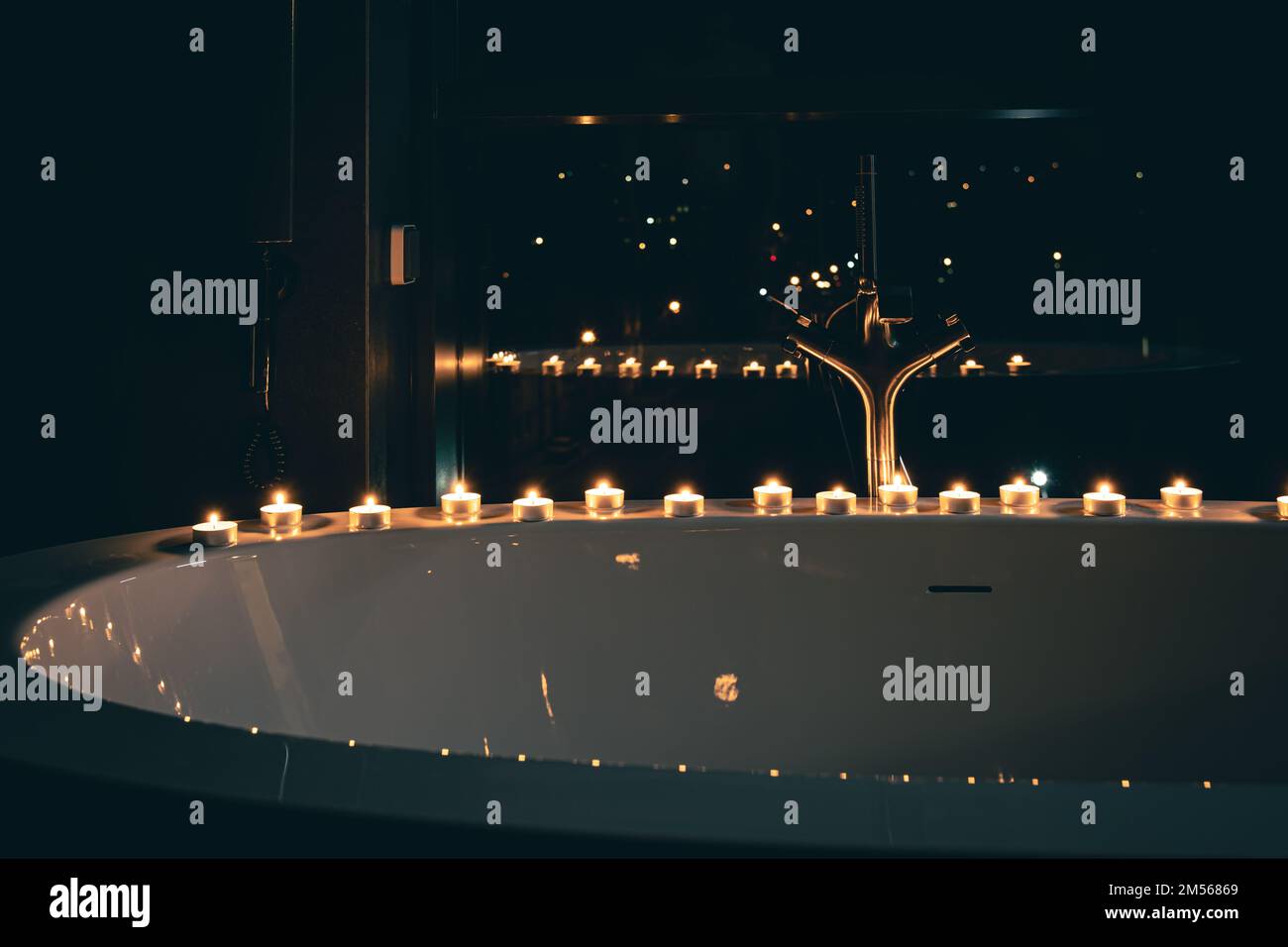 Burning candles in the bathroom in the dark Stock Photo - Alamy