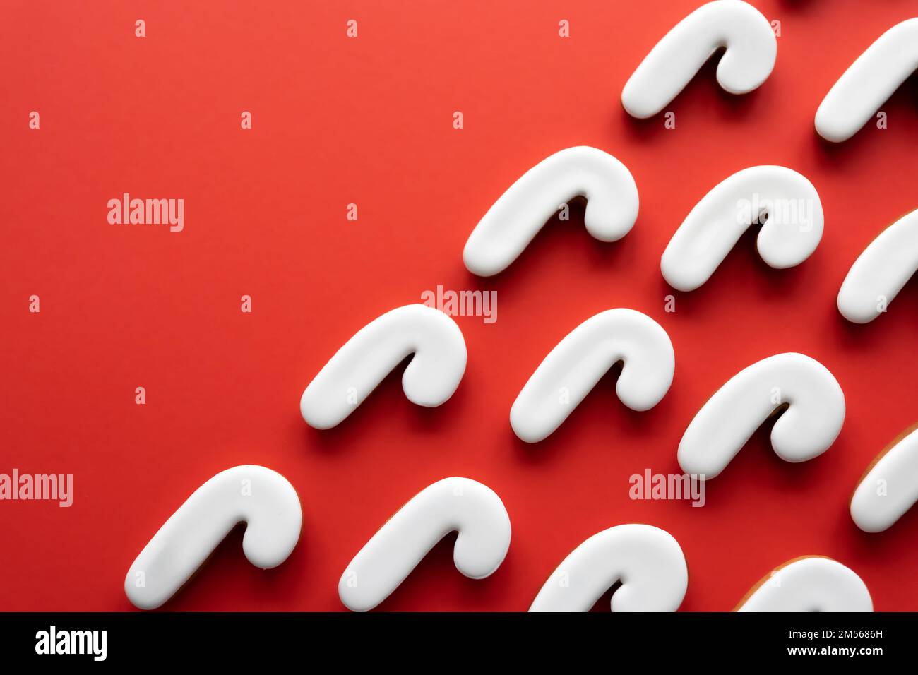 A lot of gingerbread candy cane shaped cookies on a red background ...