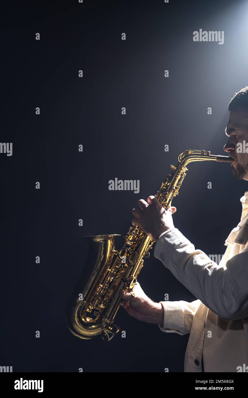 A European man plays the saxophone in the dark Stock Photo - Alamy