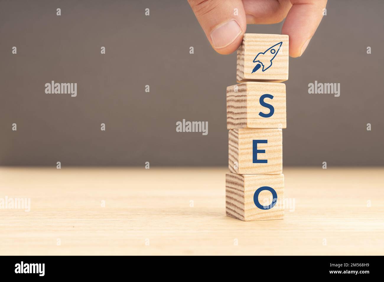 SEO or search engine optimization concept. Hand holding a wooden block ...