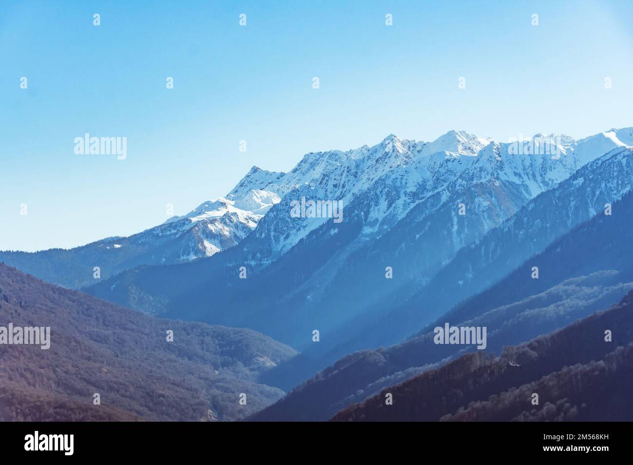 Mountain snowy landscape forest, mountain range pass blue sky. The ...
