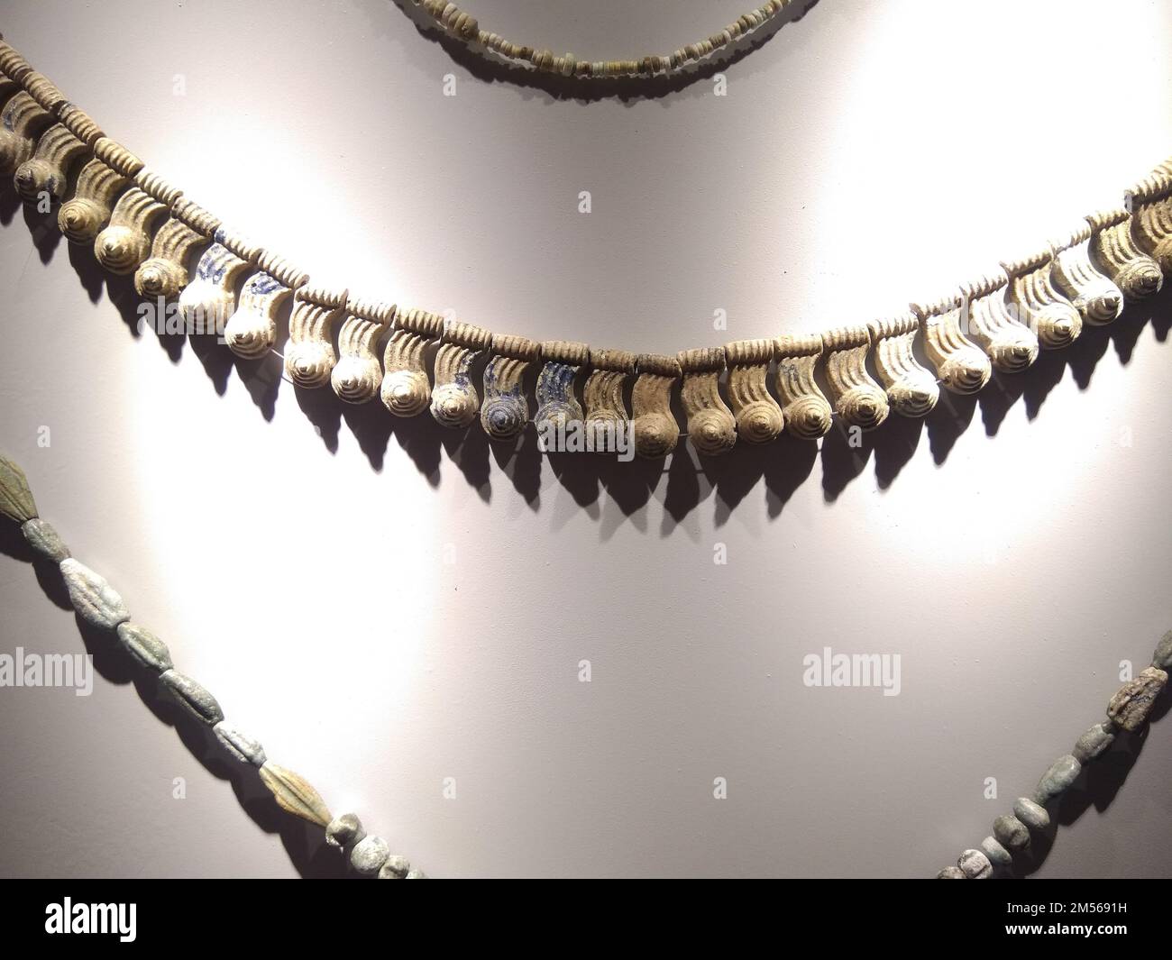 A vintage olf Ancient stone decorated Jewelry hanging on white wall ...