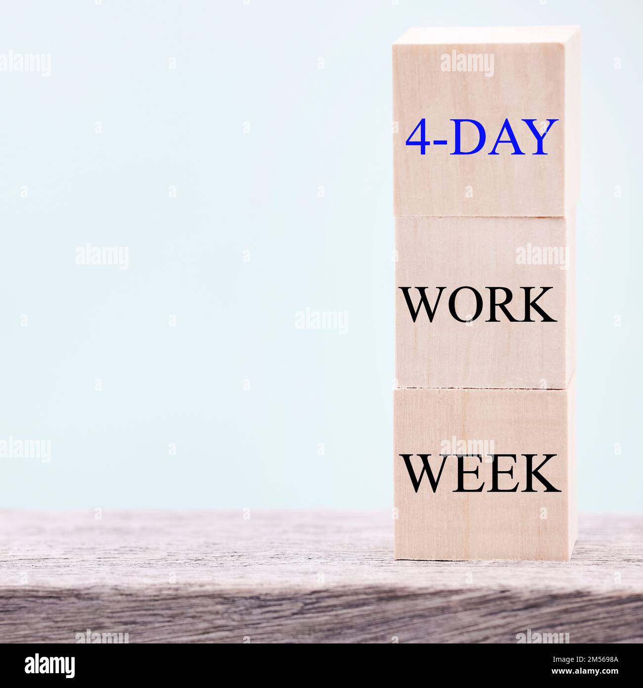 4 day working week words on wooden cube on blue background. reducing ...